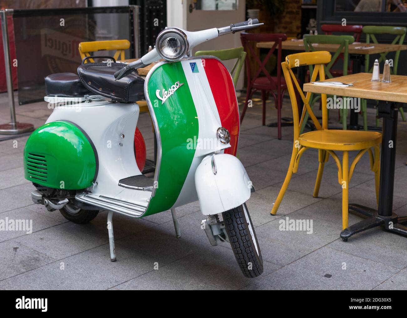 A Vespa motorcycle in Italian colours outside a restaurant in Leicester ...