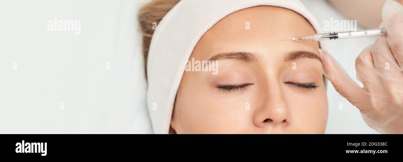 Forehead injection at spa salon. Doctor hands. Pretty female patient ...