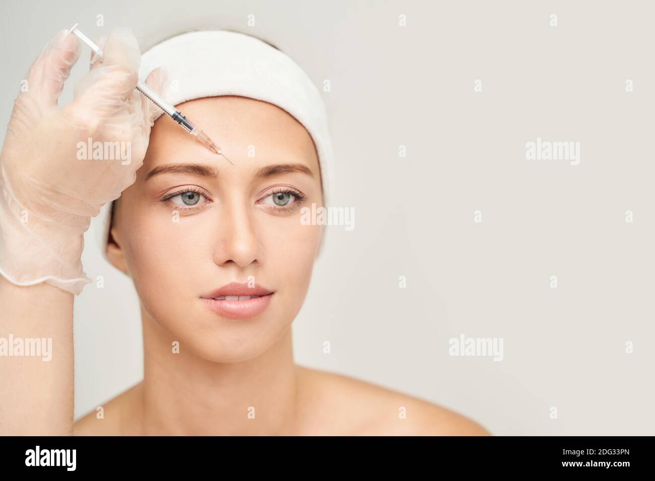 Forehead injection at spa salon. Doctor hands. Pretty female patient ...