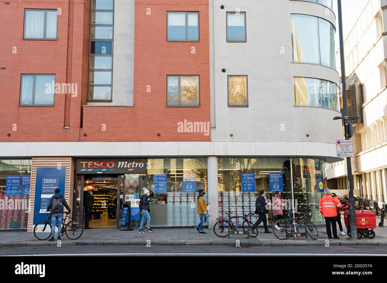 People wearing masks passing Tesco Metro store Holloway Road branch a ...