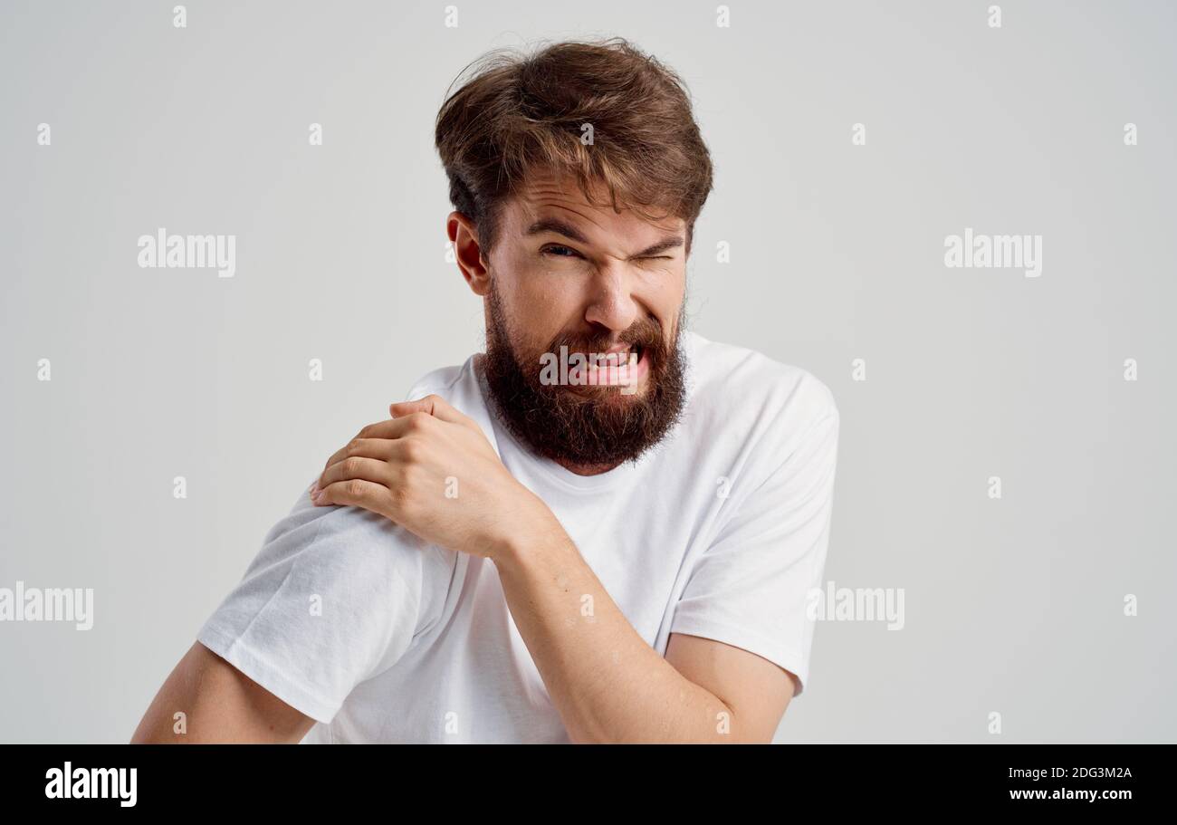 bearded man touching shoulder with hand pain dislocation medical ...