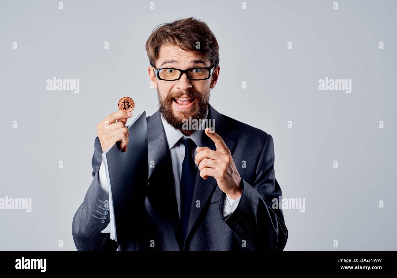 Business man with a coin in his hand on a gray background currency ...