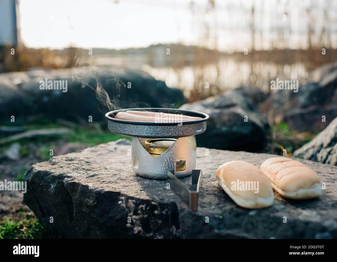 outdoor cooker with sausages and bread rolls cooking on a beach Stock ...