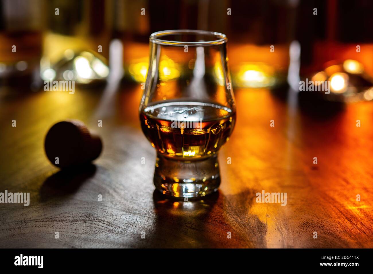 Dram of single malt scotch whisky and bottles on background, close up ...