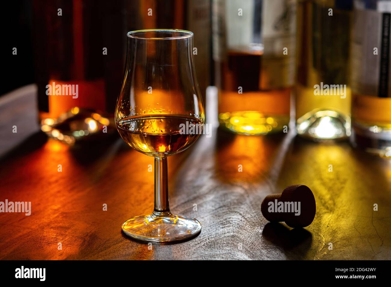 Dram of single malt scotch whisky and bottles on background, close up ...