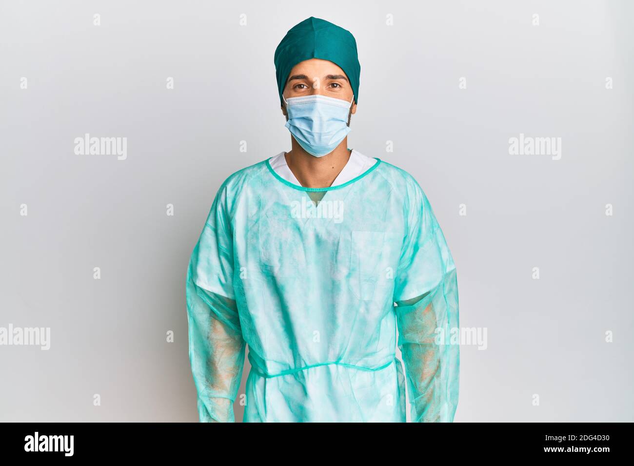 Young handsome man wearing surgeon uniform and medical mask with a ...