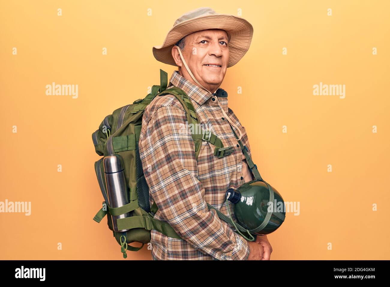 Senior man with grey hair wearing hiker backpack and water canteen ...