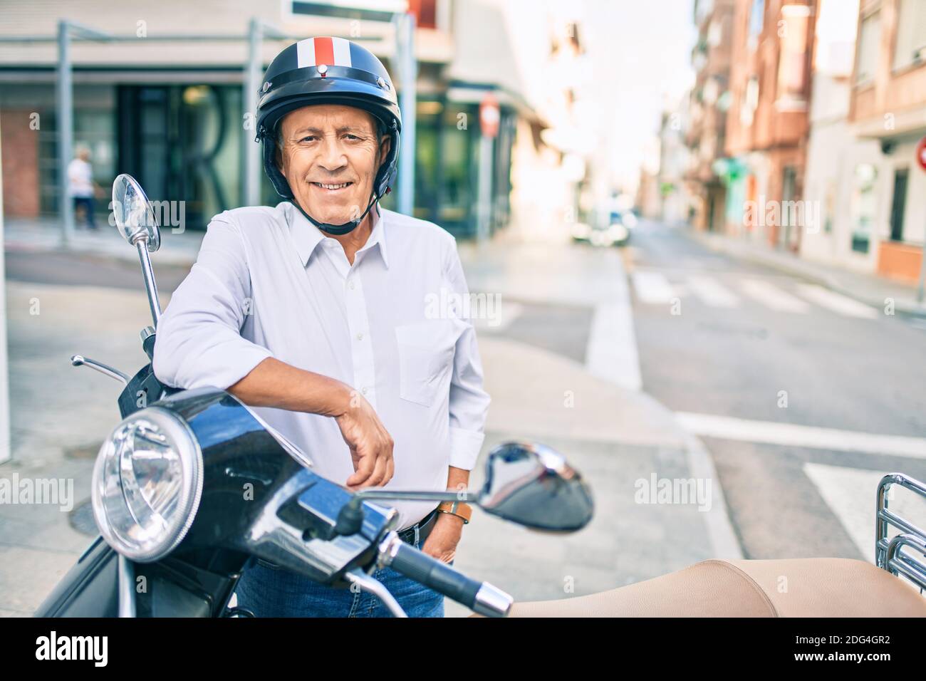Senior motorcyclist man smiling happy wearing moto helmet at the city ...