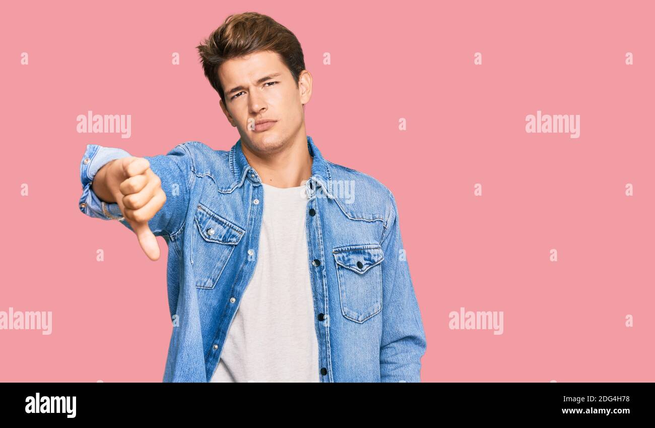 Handsome caucasian man wearing casual denim jacket looking unhappy and ...