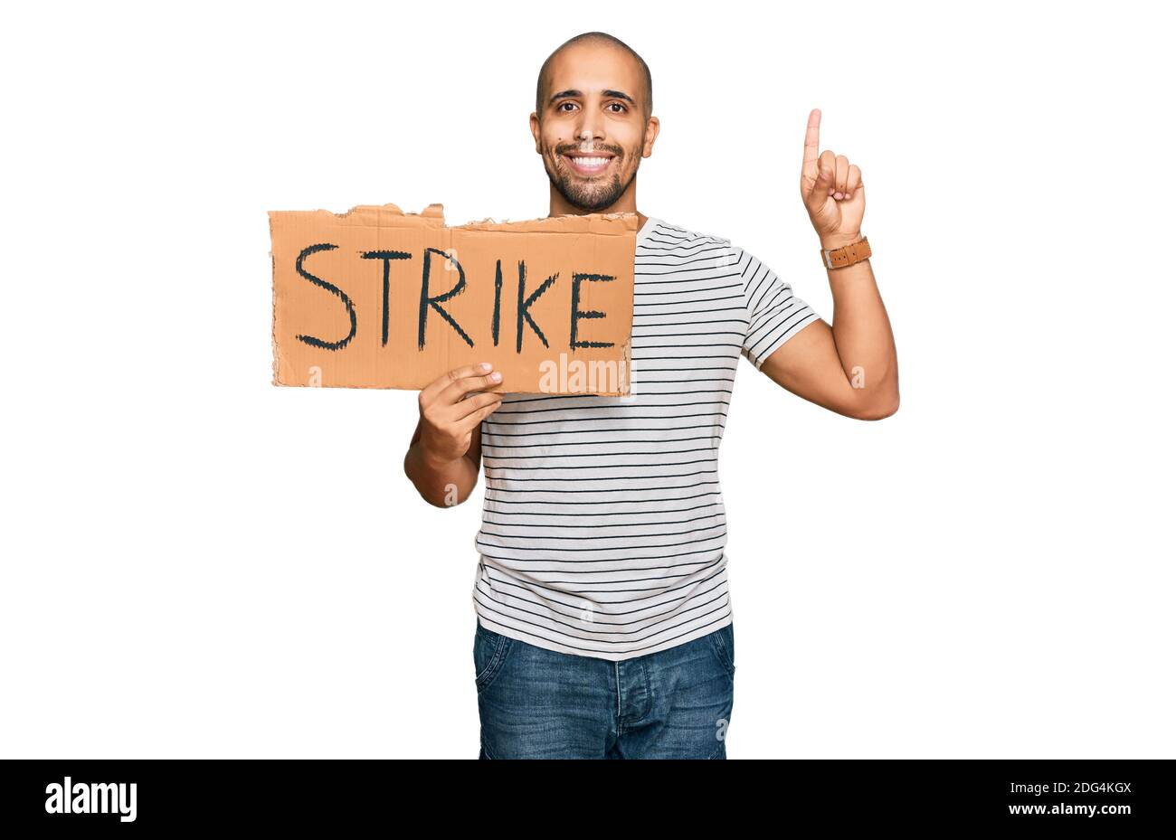Hispanic adult man holding strike banner cardboard surprised with an ...