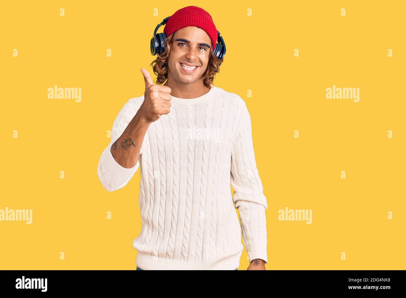 Young hispanic man listening to music using headphones doing happy ...