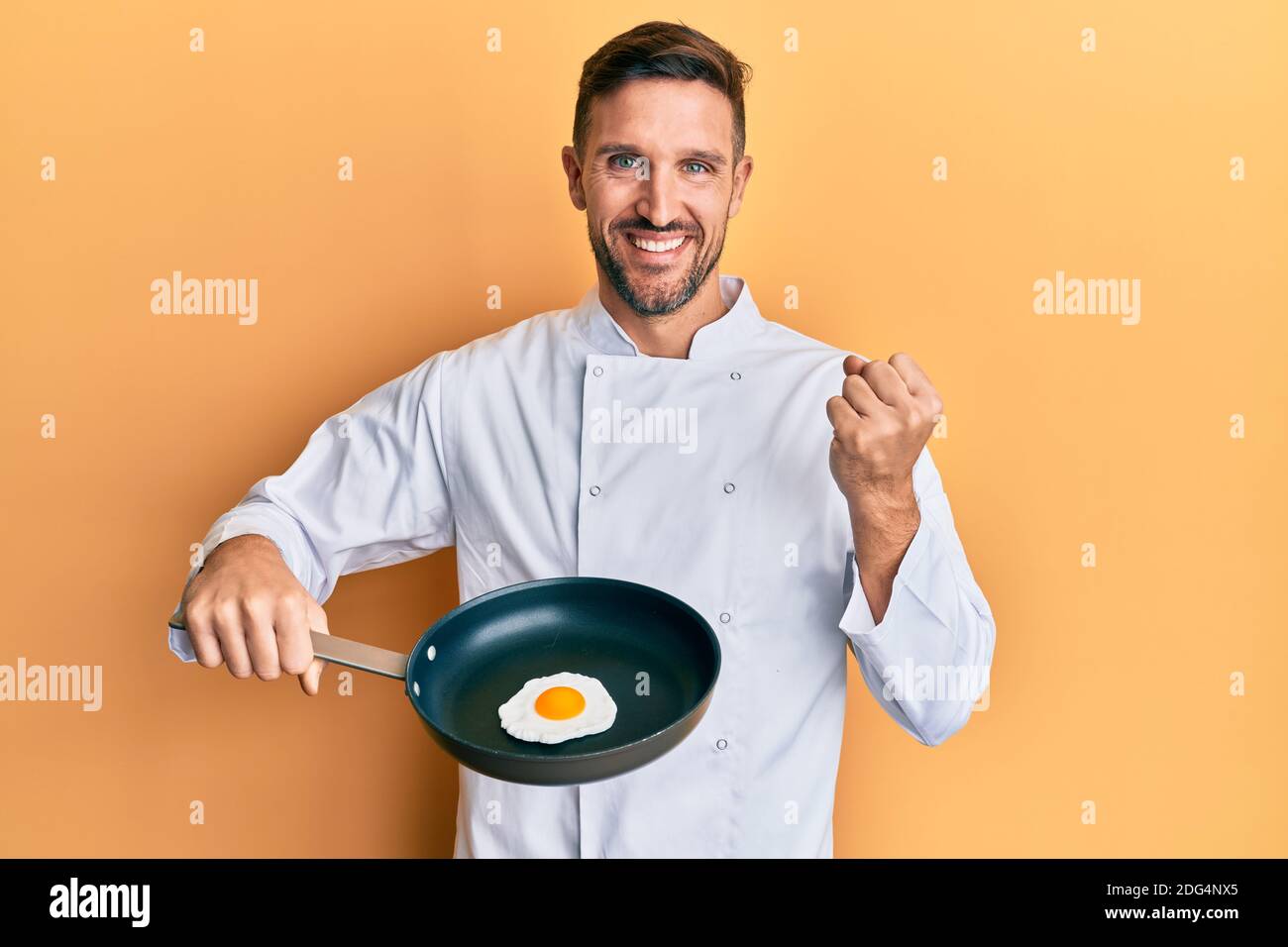 Handsome man with beard professional chef cooking fried egg screaming ...