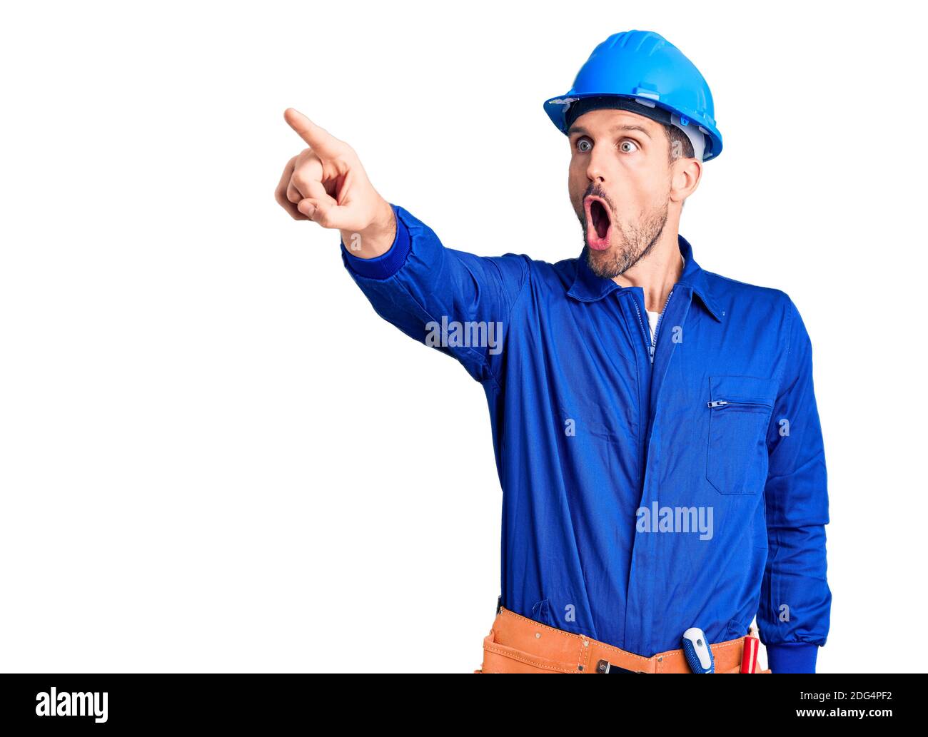 Young handsome man wearing worker uniform and hardhat pointing with ...