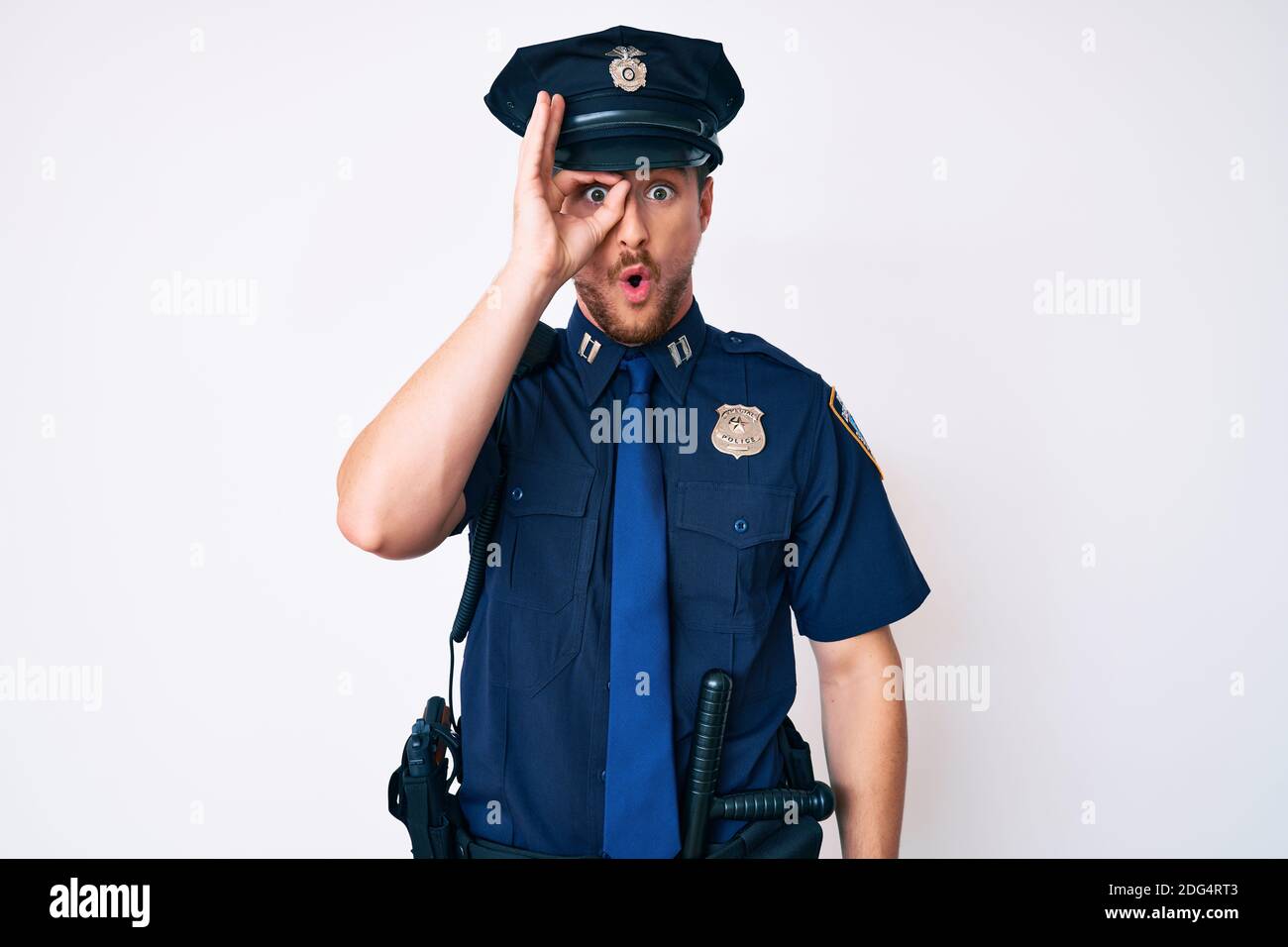 Young caucasian man wearing police uniform doing ok gesture shocked ...