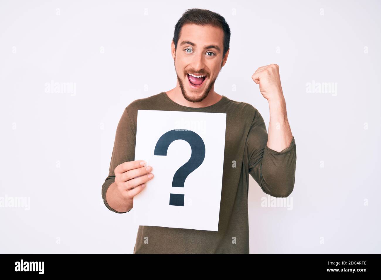 Young handsome man holding question mark screaming proud, celebrating ...
