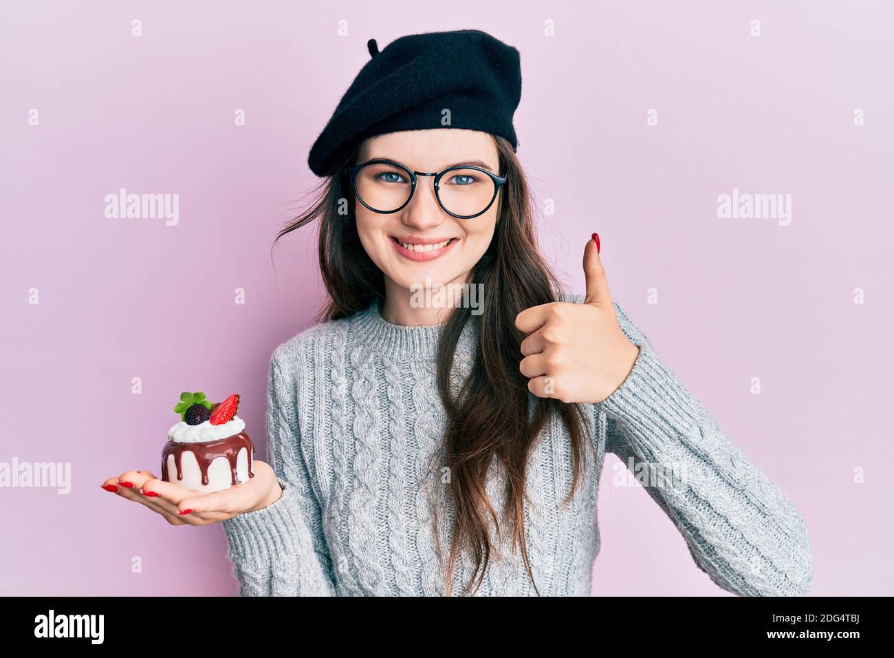 Young beautiful caucasian girl wearing french beret holding cake ...