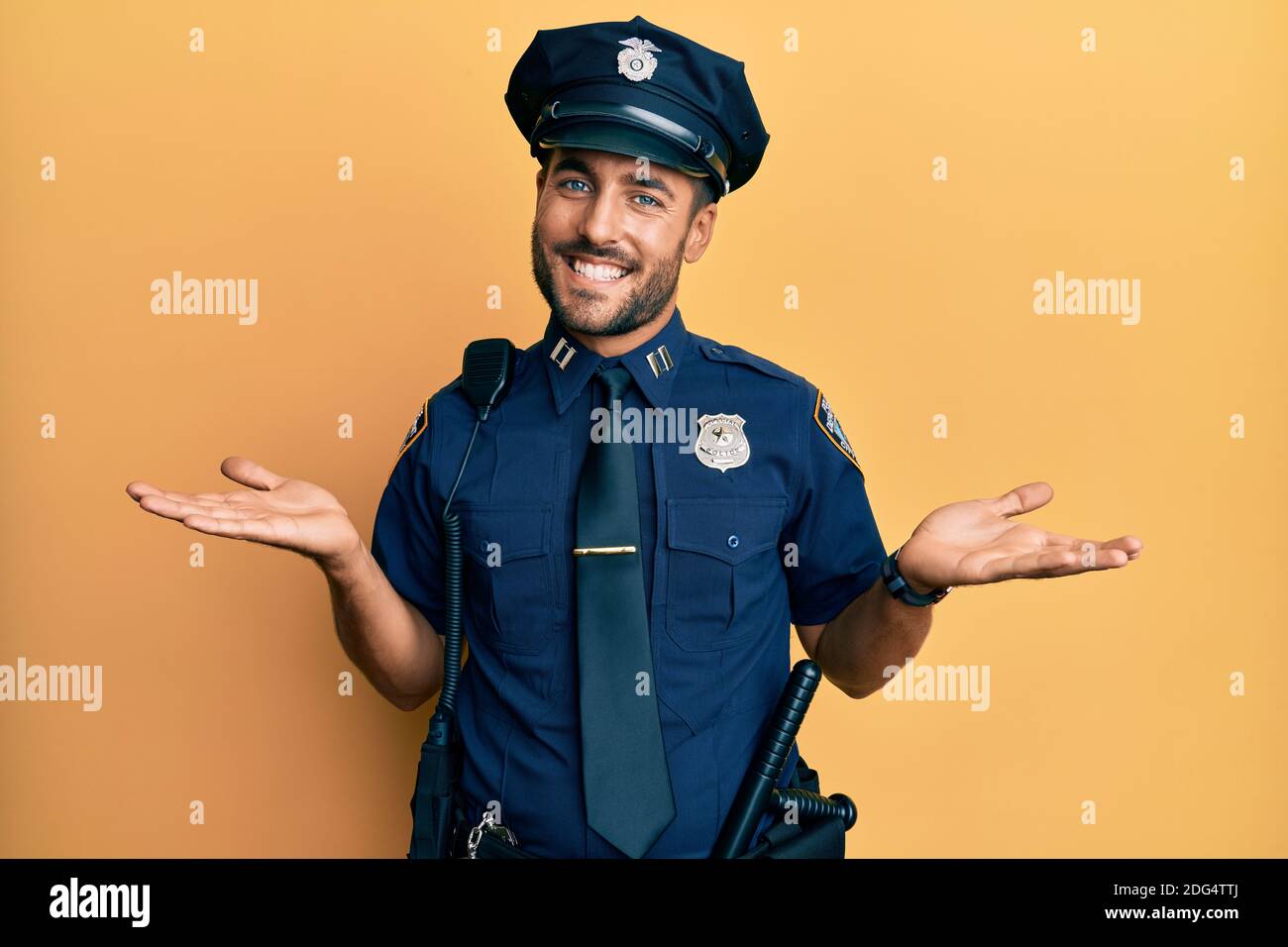 Handsome hispanic man wearing police uniform smiling showing both hands ...