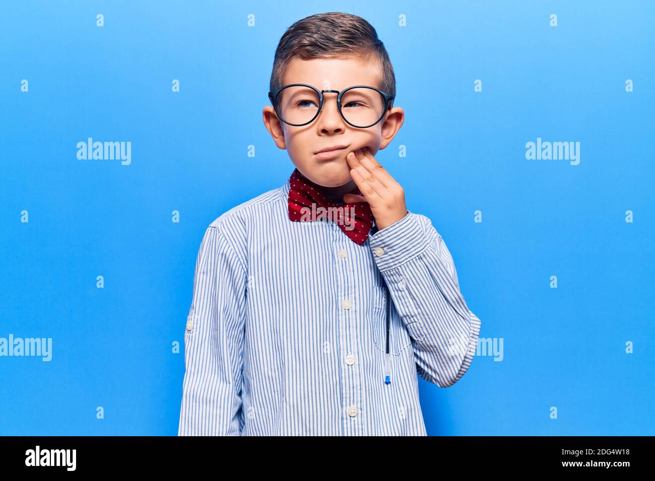 Cute blond kid wearing nerd bow tie and glasses touching mouth with ...