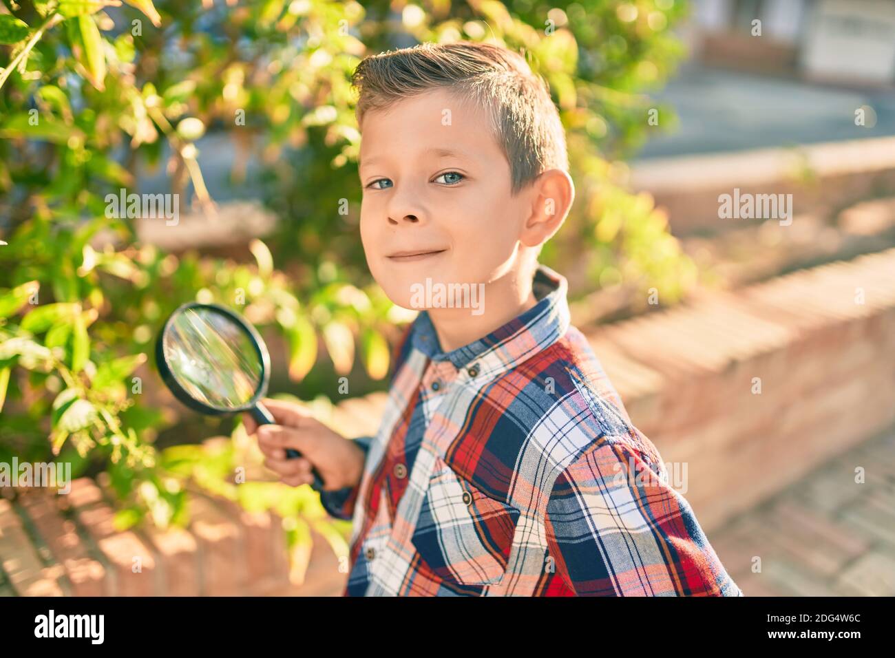 Adorable caucasian explorer boy using magnifying glass at the park Stock Photo - Alamy