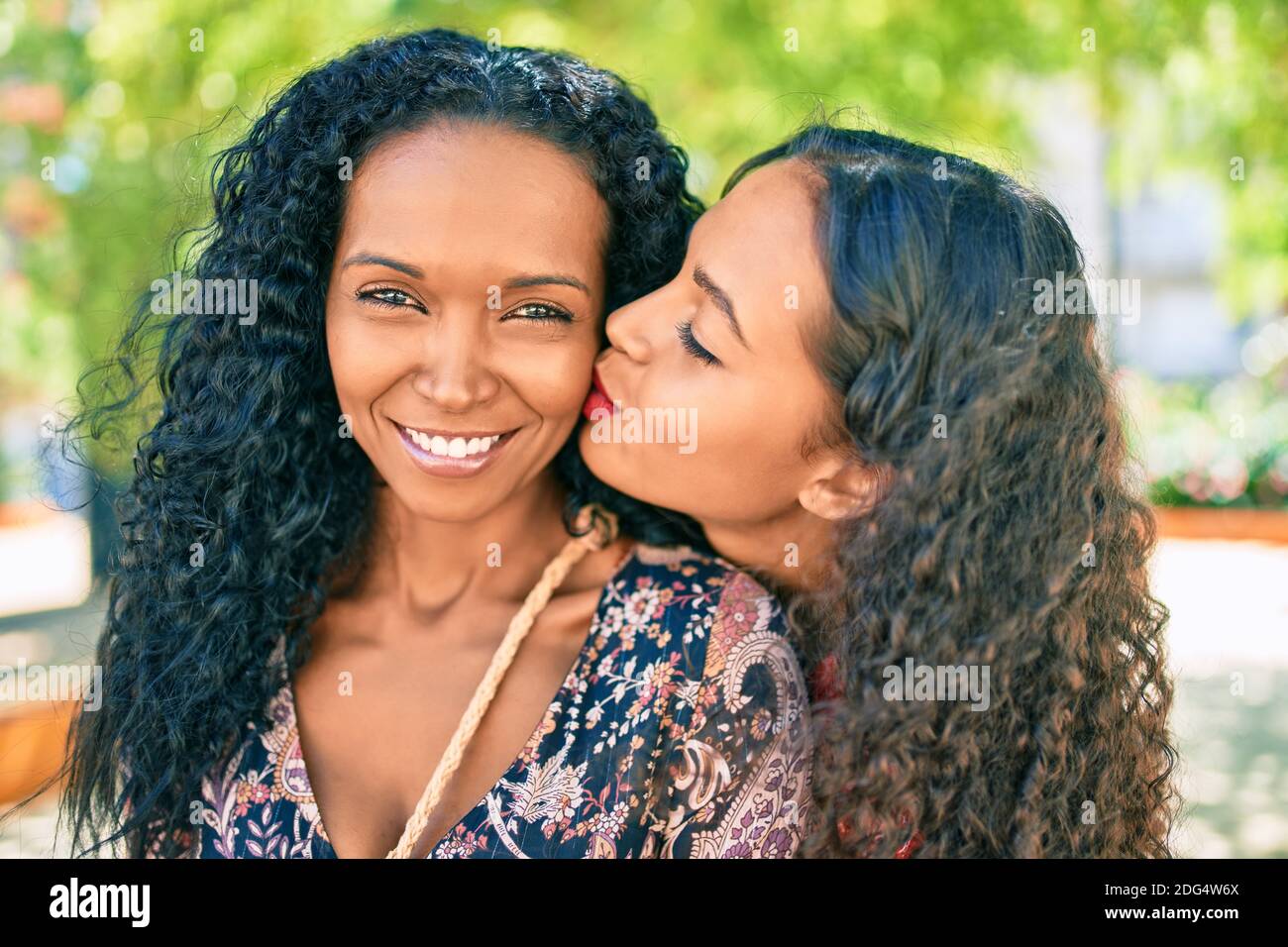 African american mother and daughter smiling happy hugging and kissing at the park Stock Photo ...