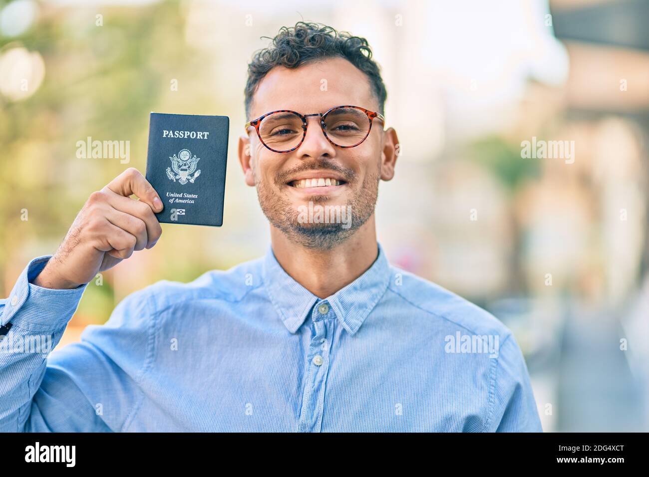 Young hispanic businessman smiling happy holding united states passport ...
