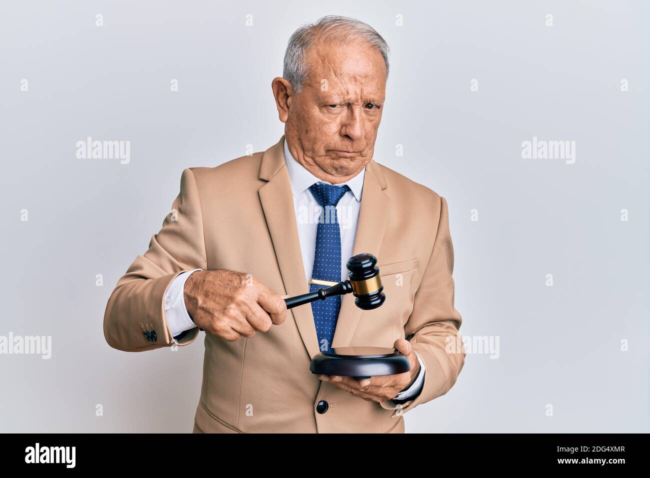 Senior caucasian judge man using gavel depressed and worry for distress ...
