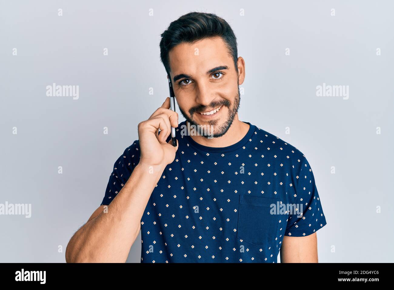 Young hispanic man having conversation talking on the smartphone ...