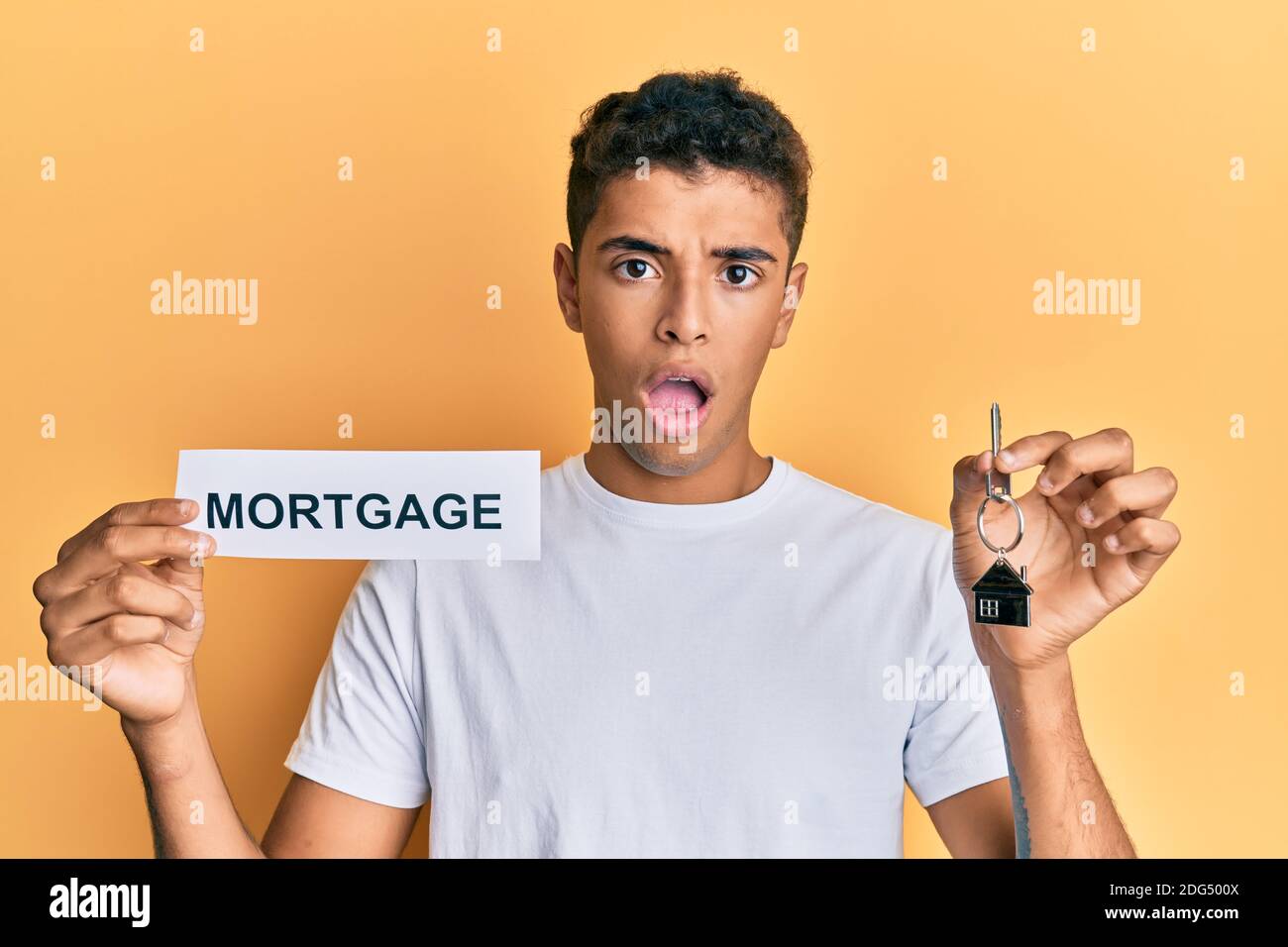 Young handsome african american man holding paper with mortgage word ...