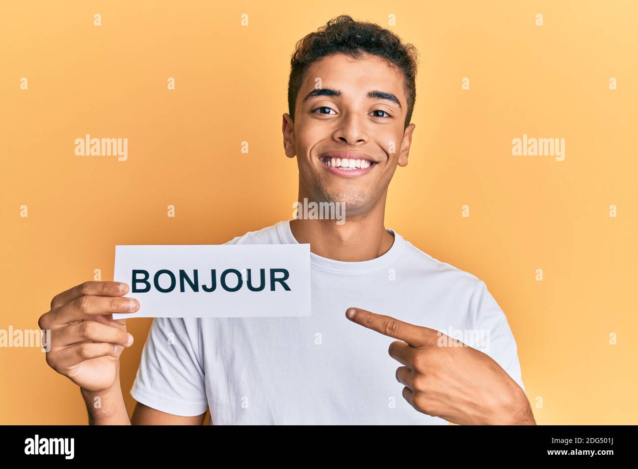 Young handsome african american man holding bonjour french greeting ...