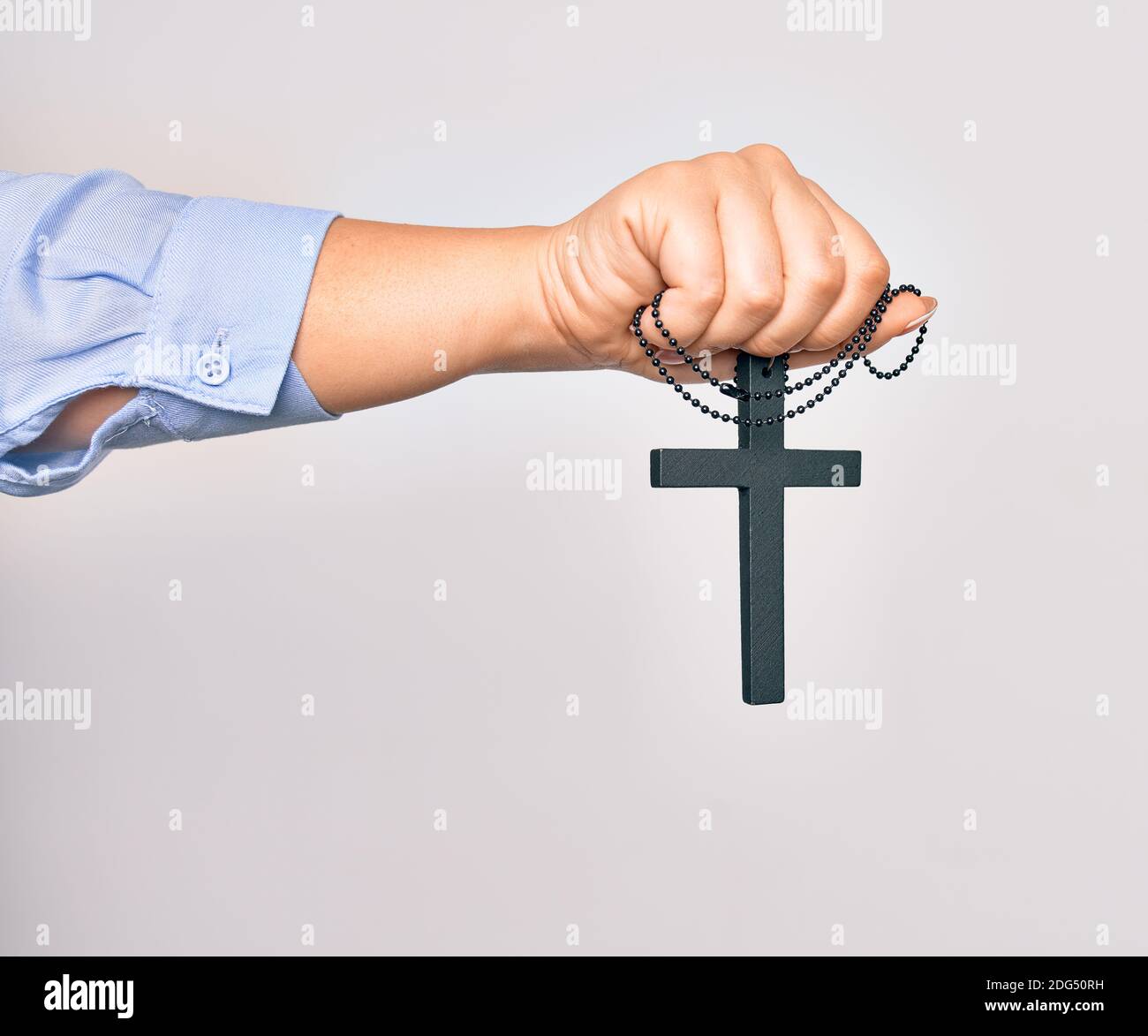 Hand of caucasian young catholic woman holding christian cross over ...