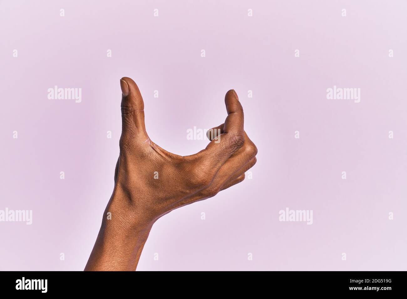 Arm and hand of black middle age woman over pink isolated background ...