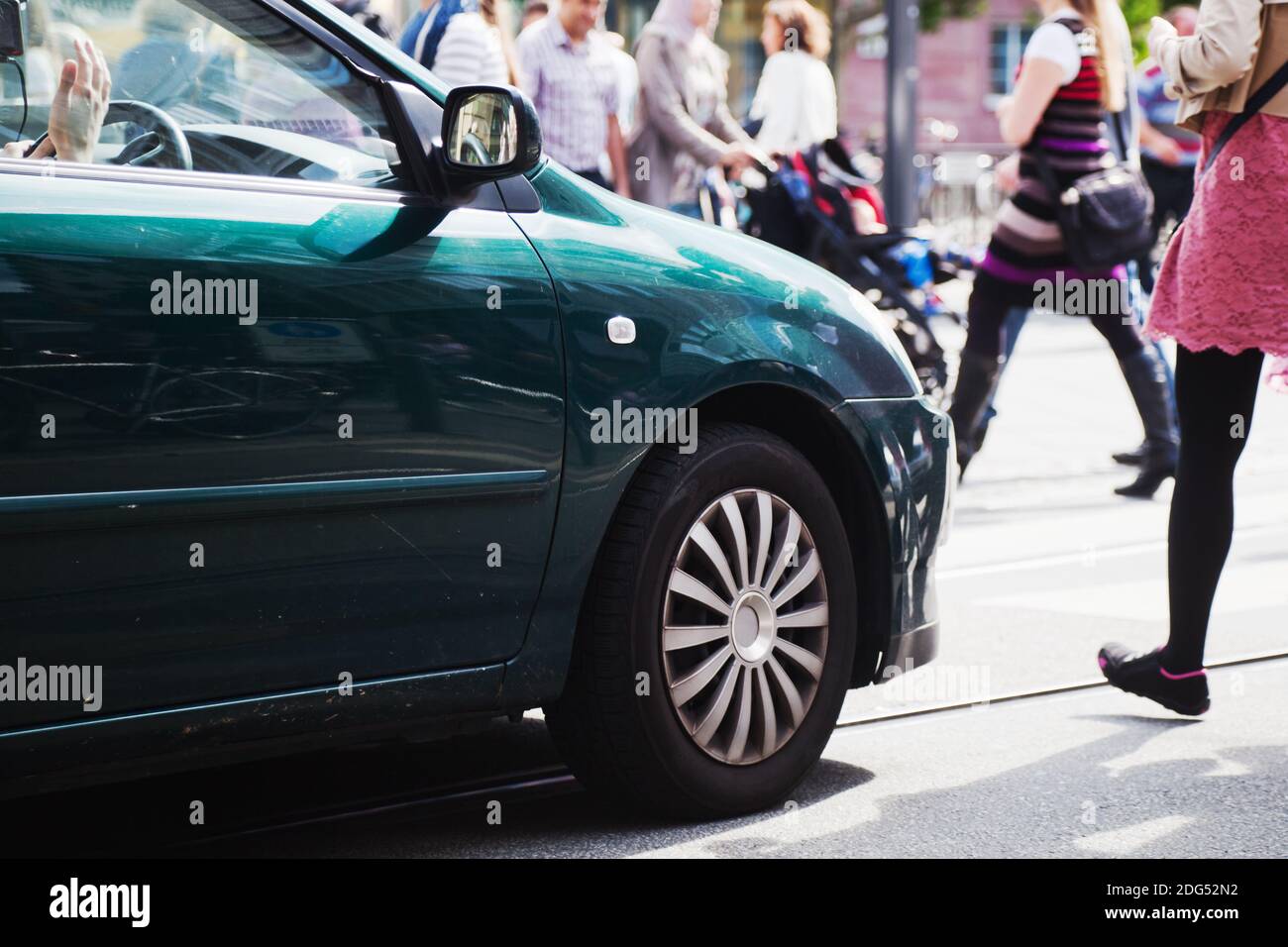 Car waiting at a crosswalk for crossing people Stock Photo - Alamy