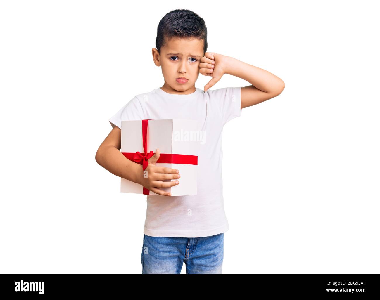 Little cute boy kid holding gift with angry face, negative sign showing ...