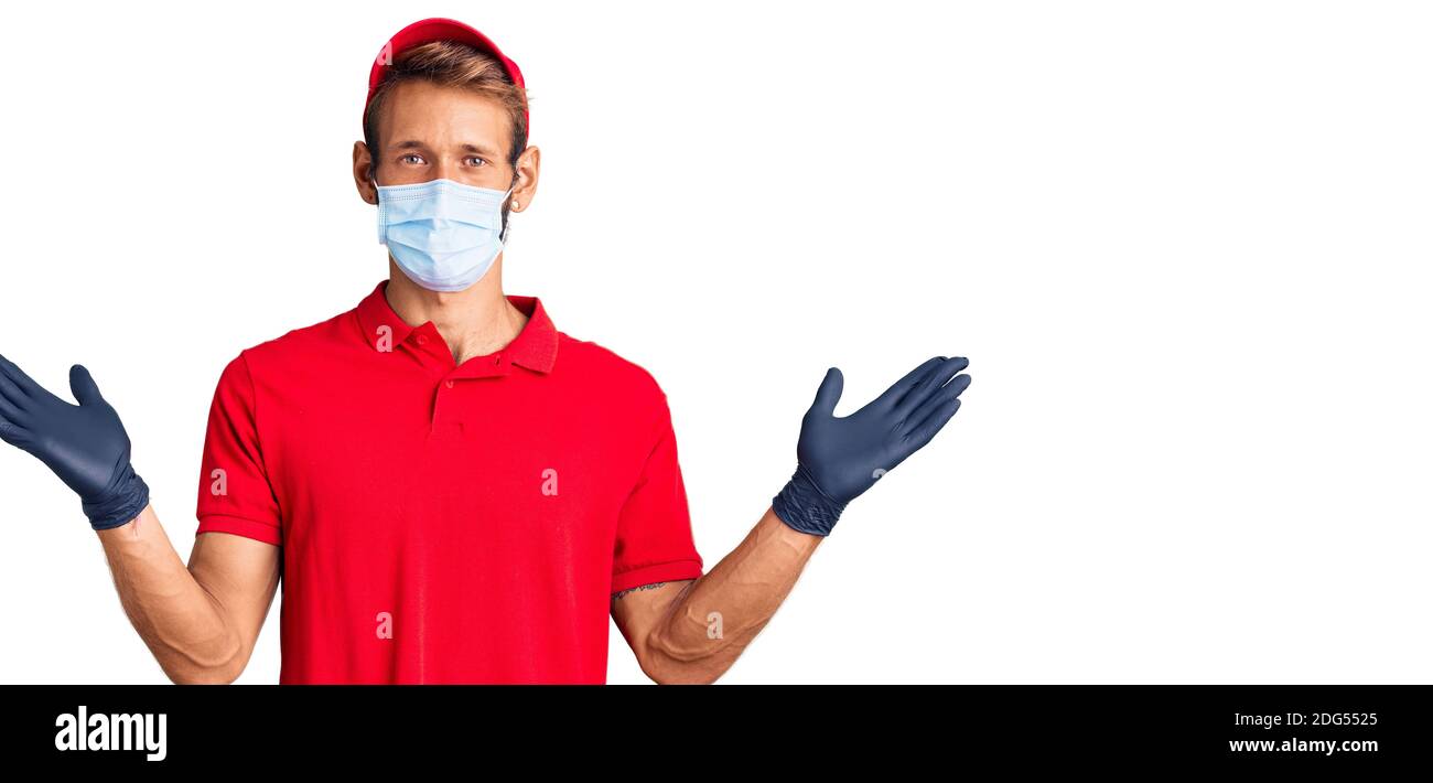 Handsome Blond Man With Beard Wearing Delivery Uniform And Medical Mask