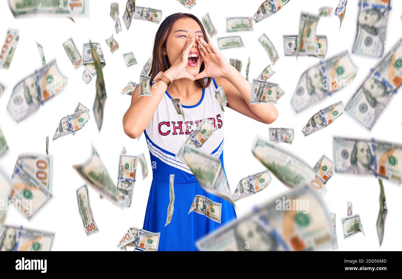 Young beautiful chinese girl wearing cheerleader uniform shouting angry ...