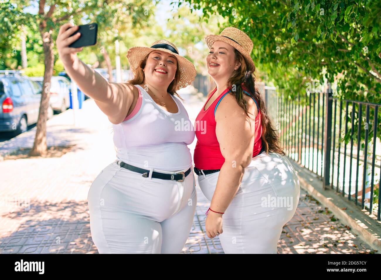 Two plus size overweight sisters twins women smiling taking a selfie ...