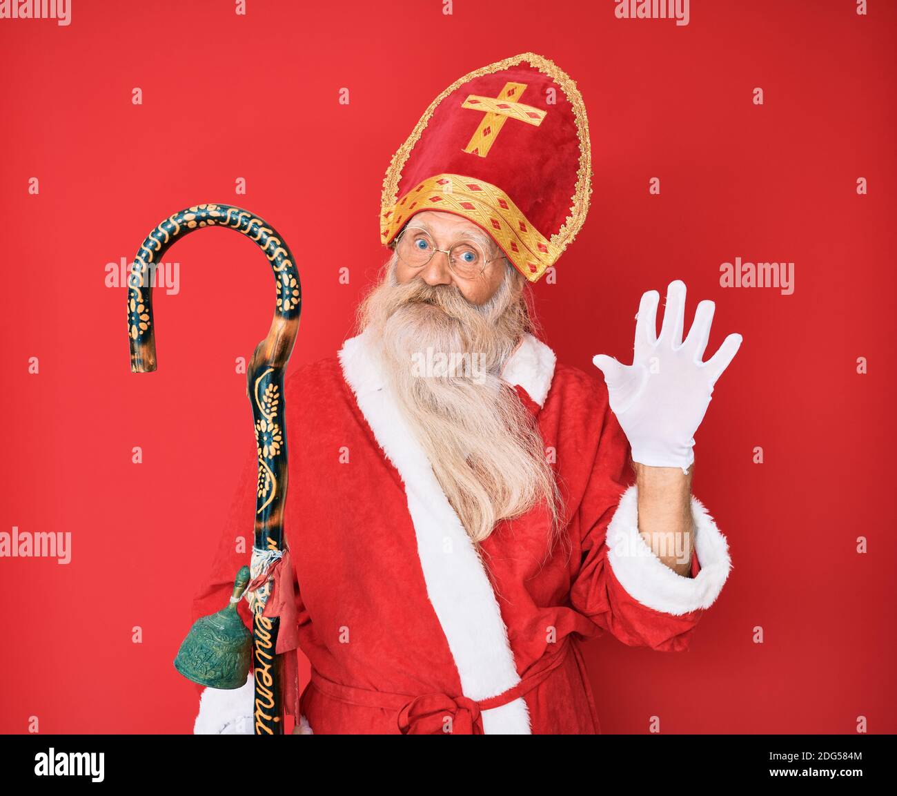 Old senior man with grey hair and long beard wearing traditional saint ...