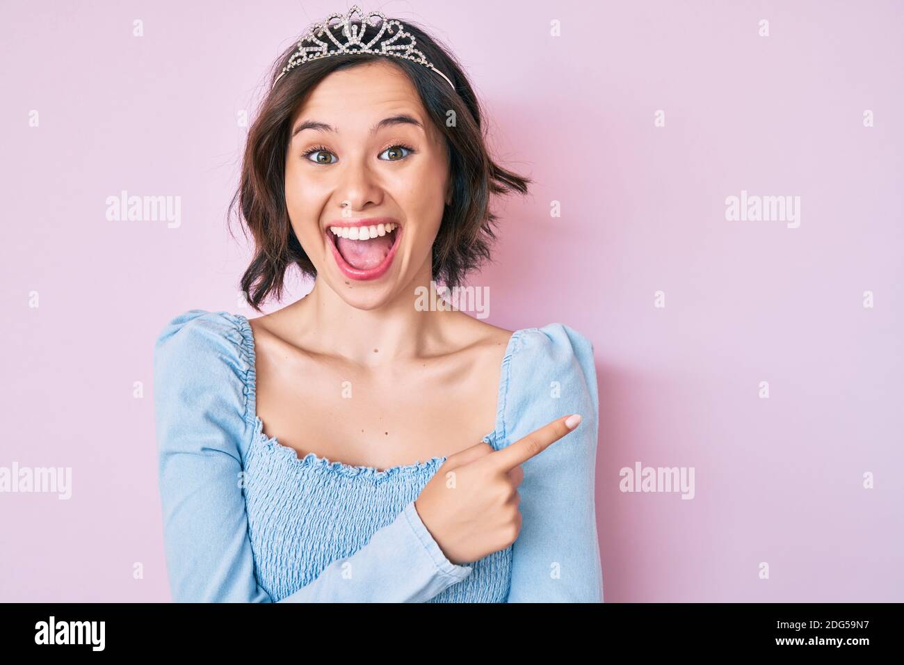 Young beautiful girl wearing princess crown celebrating crazy and ...