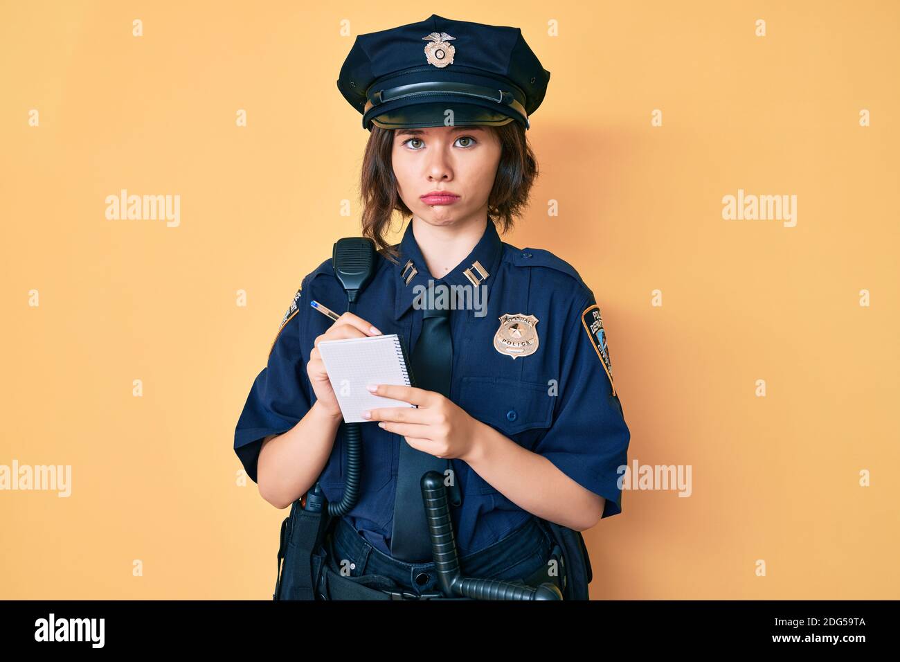 Young beautiful girl wearing police uniform writing traffic fine ...