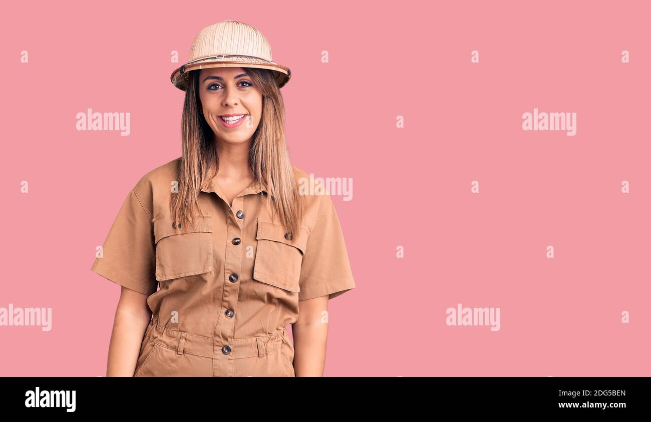Young beautiful woman wearing explorer hat looking positive and happy ...