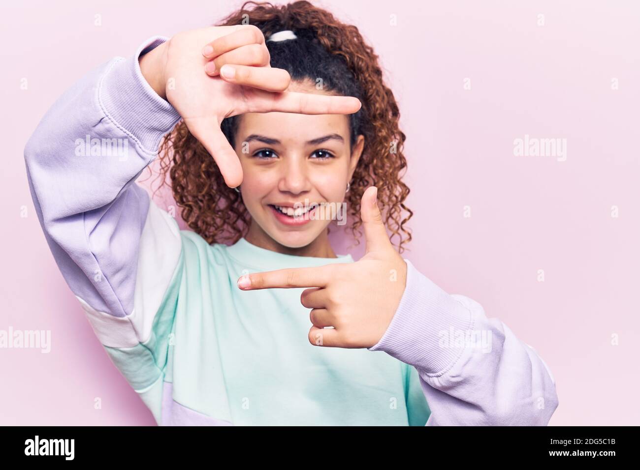 Beautiful kid girl with curly hair wearing casual clothes smiling ...