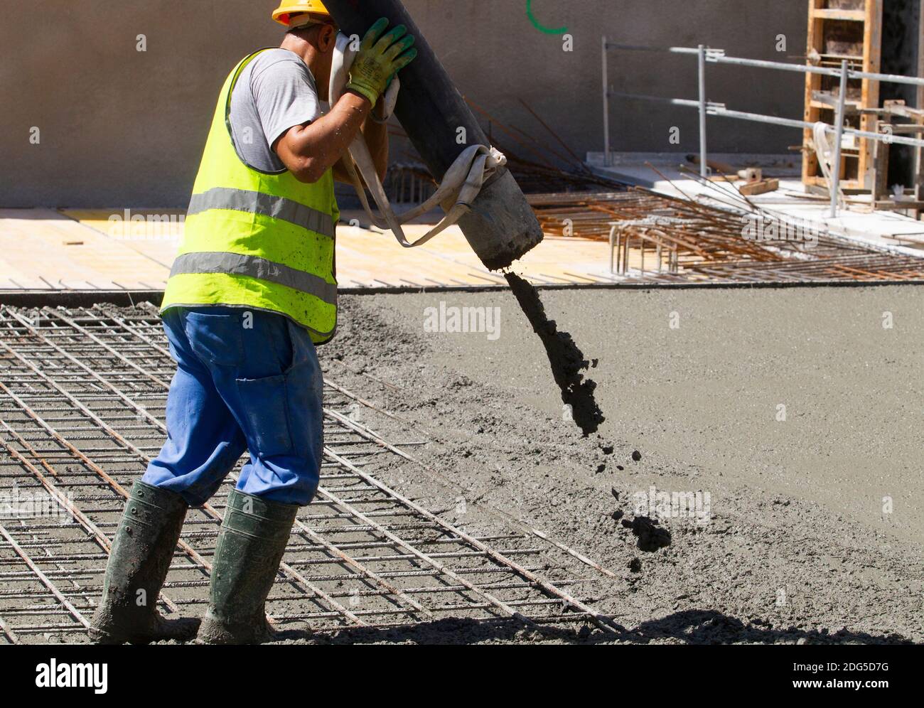 Worker filling the foundation slab of a building under construction ...