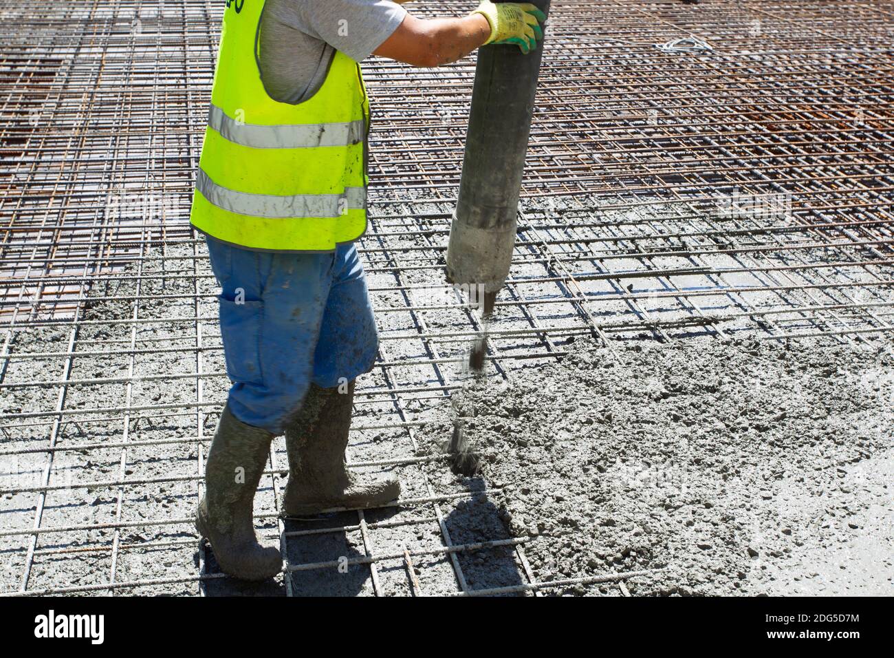 Worker filling the foundation slab of a building under construction ...