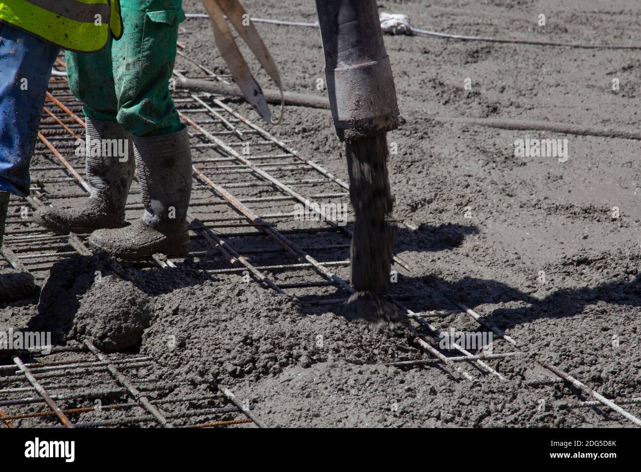 worker filling the foundation slab of a building under construction ...