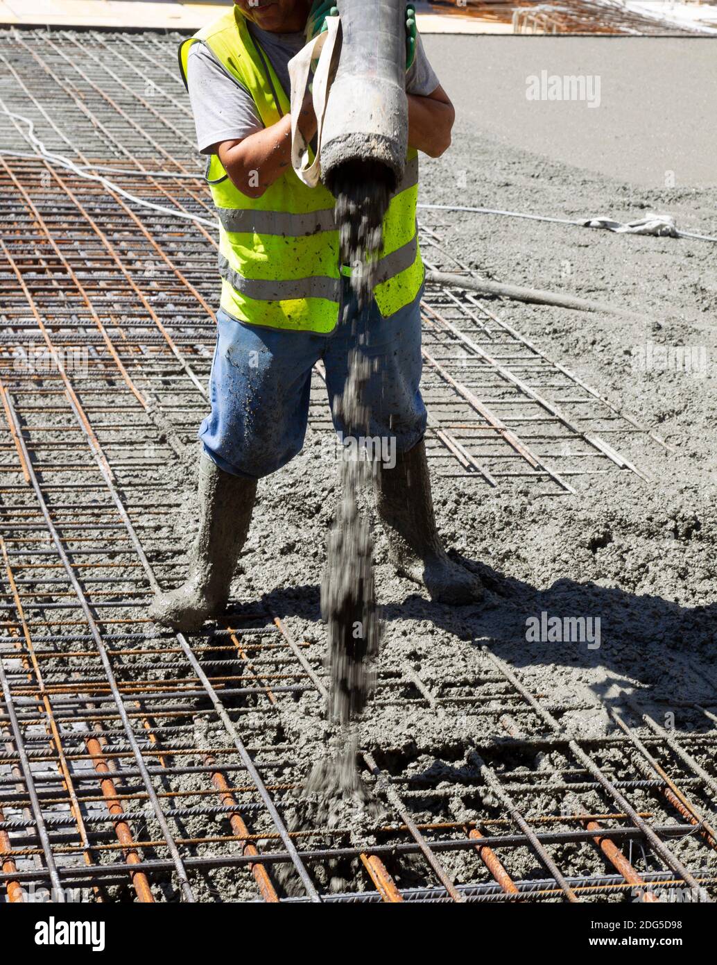 Worker filling the foundation slab of a building under construction ...