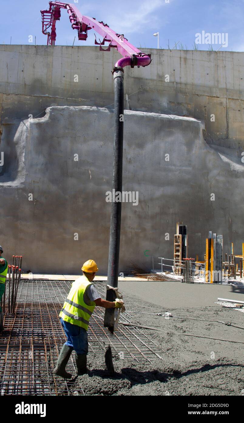 Worker filling the foundation slab of a building under construction ...