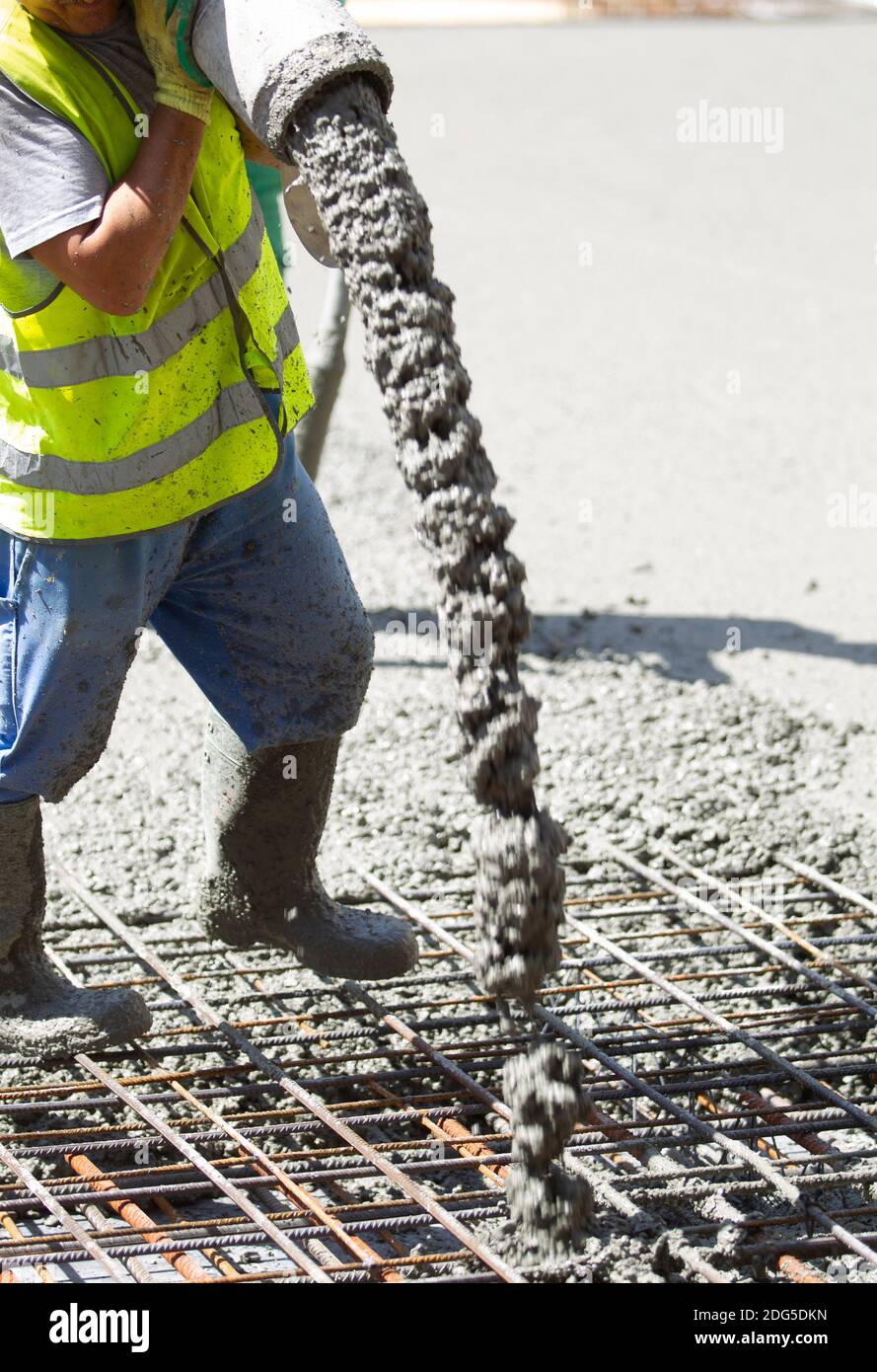 Worker filling the foundation slab of a building under construction ...