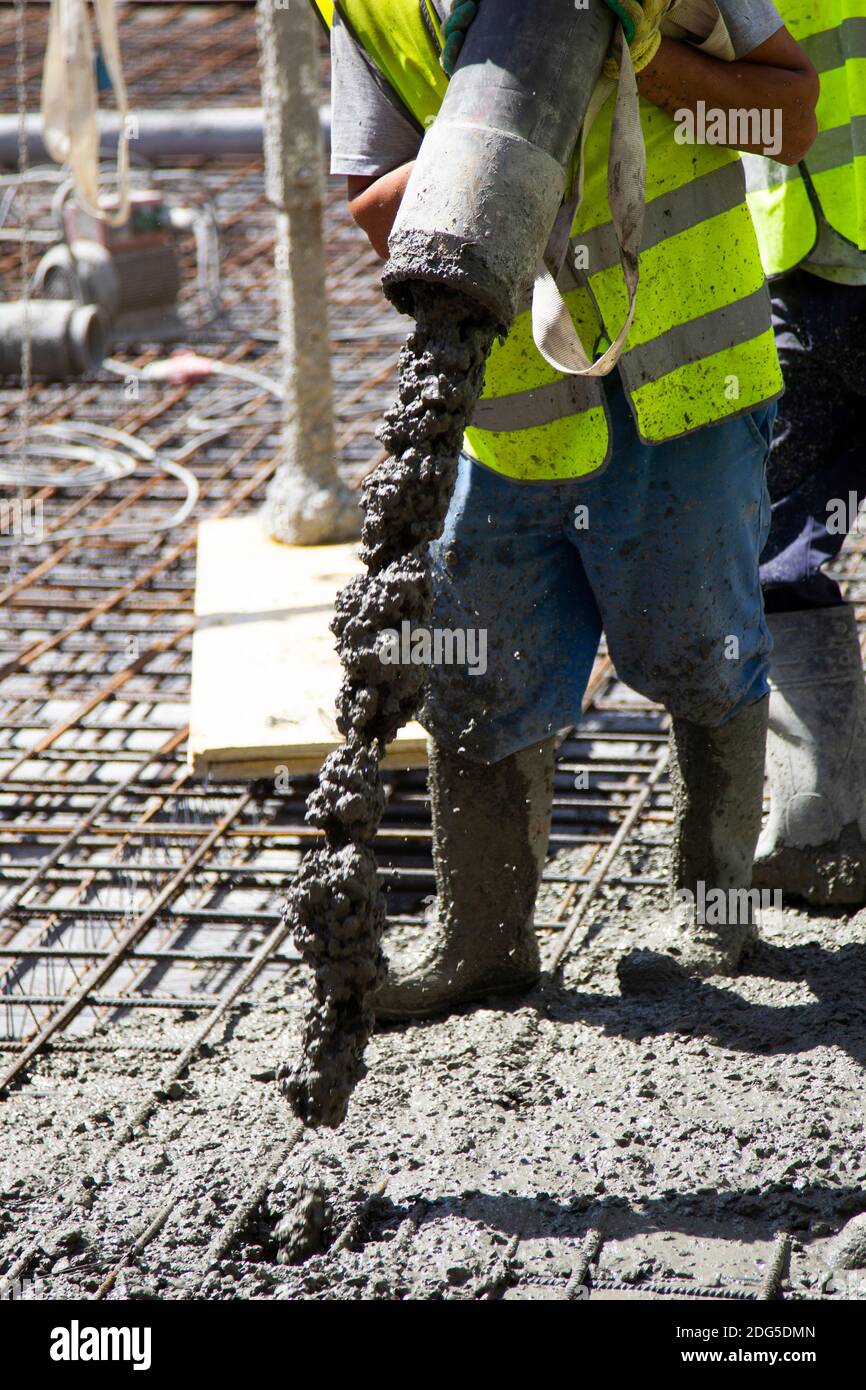 Worker filling the foundation slab of a building under construction ...