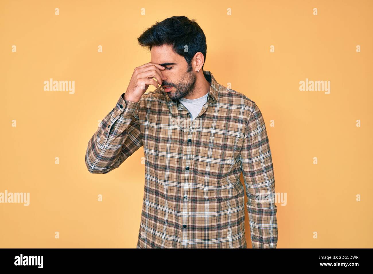 Handsome hispanic man with beard wearing casual clothes tired rubbing ...