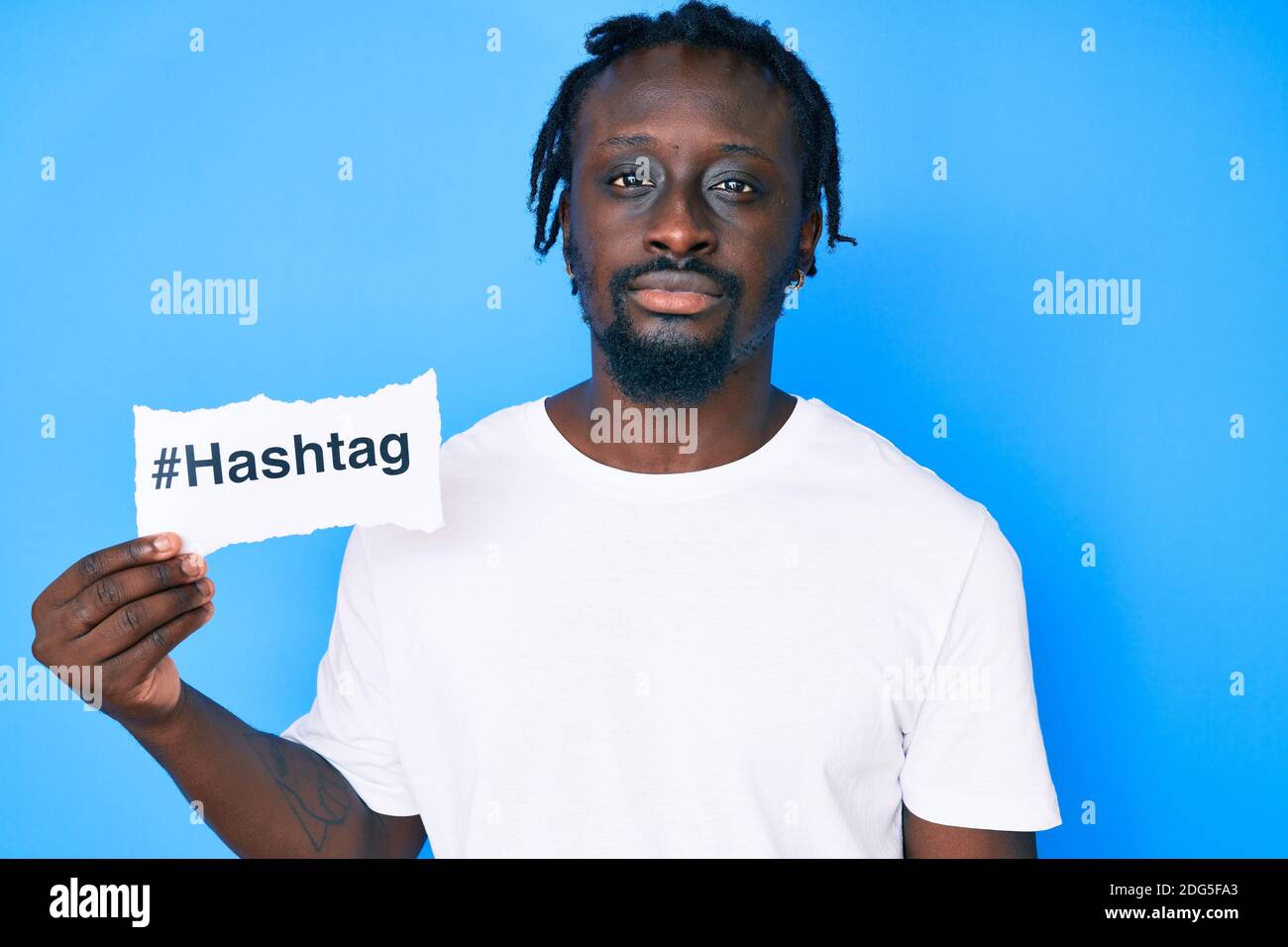 Young african american man with braids holding hashtag paper thinking ...
